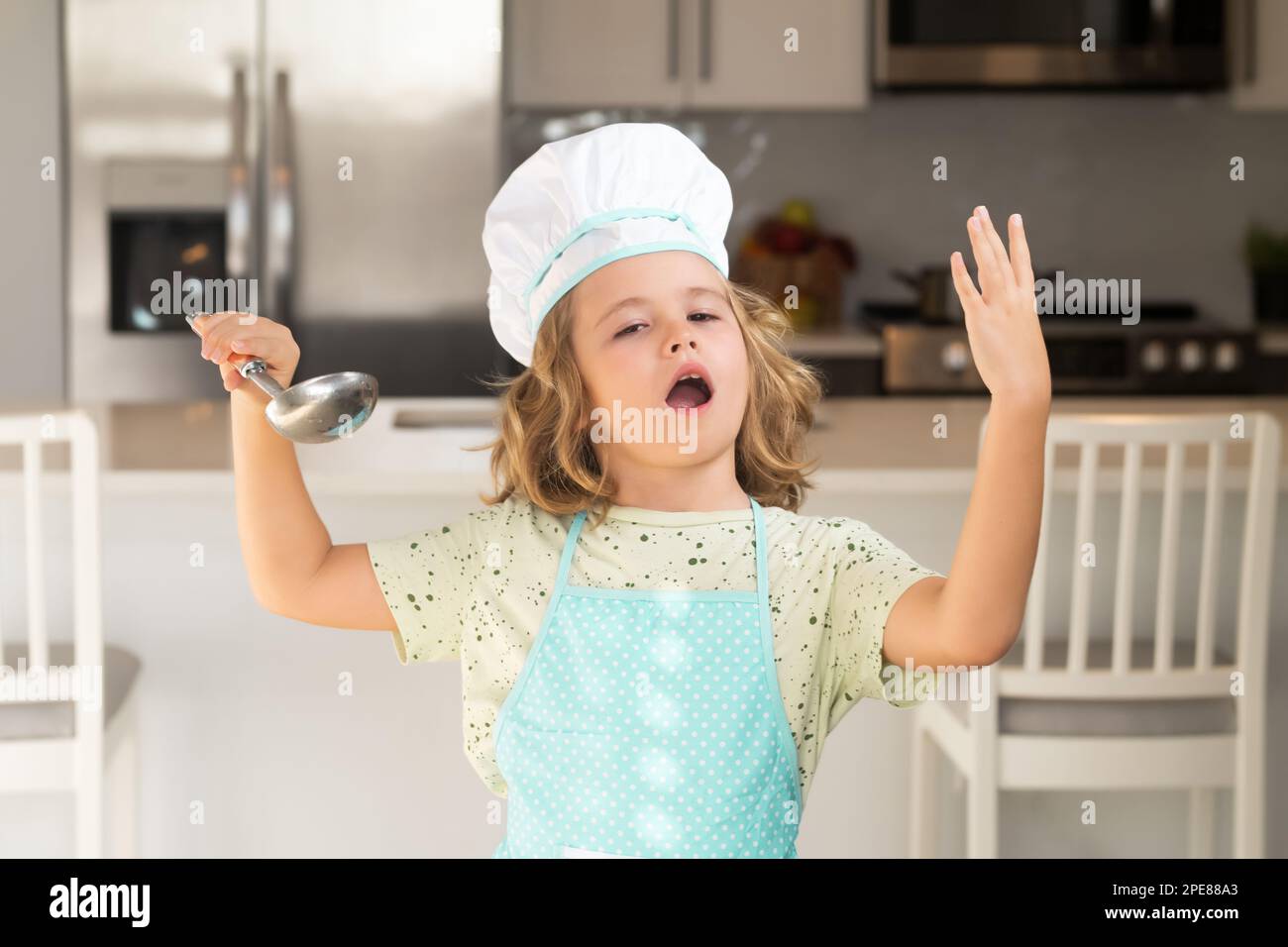 Child chef cook is learning how to make a cake in the home kitchen ...