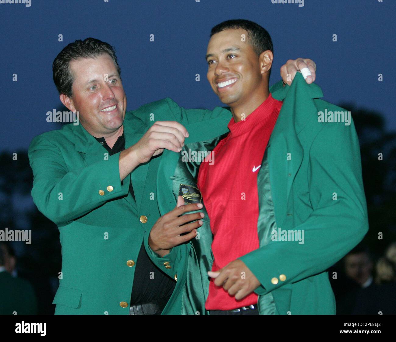 Tiger Woods, right, gets the Green Jacket from Phil Mickelson, left ...