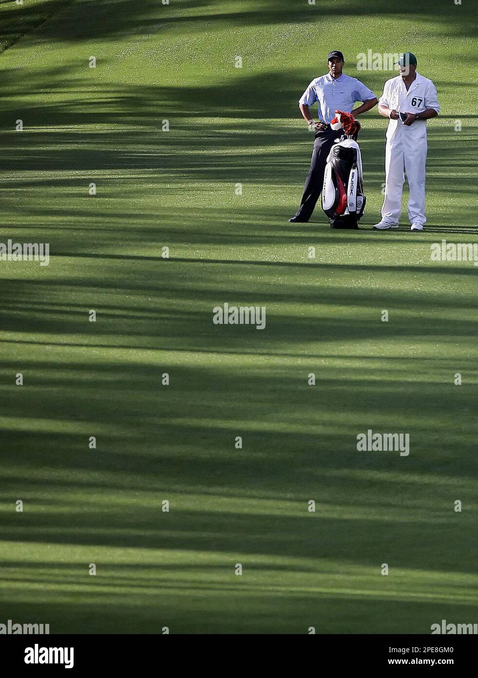 Tiger Woods and his caddie Steve Williams stand among the long shadows ...