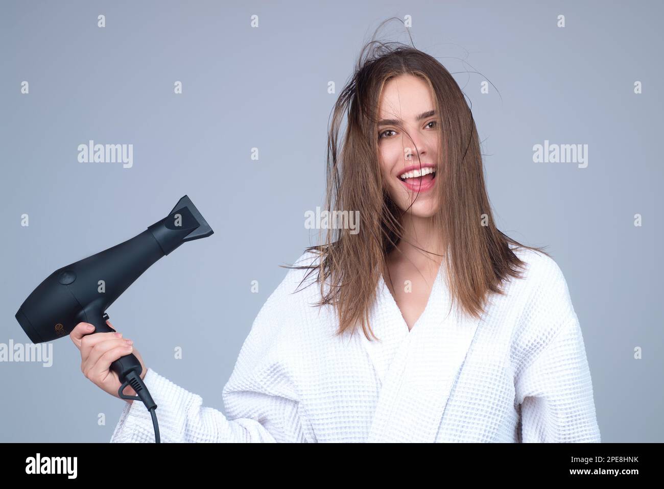 Woman with hair dryer on studio background. Girl hold hairdryer. Young ...