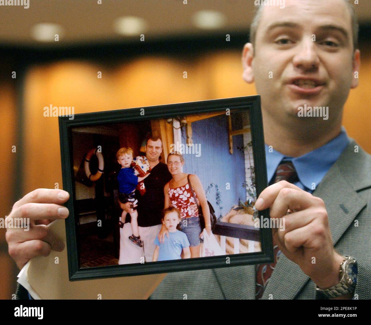 Robert Doyle holds a family picture of his wife Tricia and their two ...