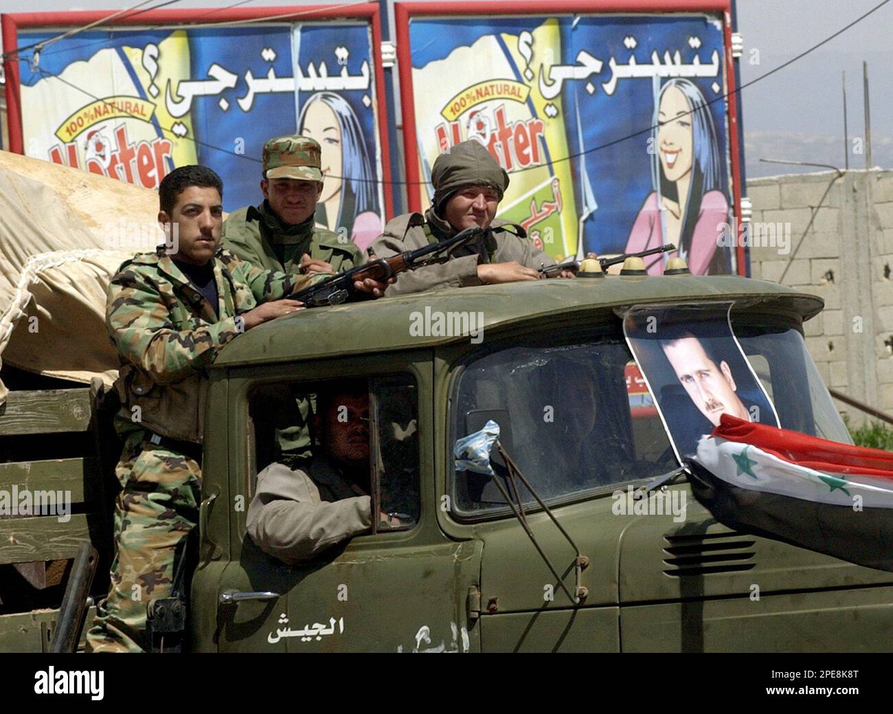 Syrian soldiers ride on an army truck with a poster of Syrian President ...