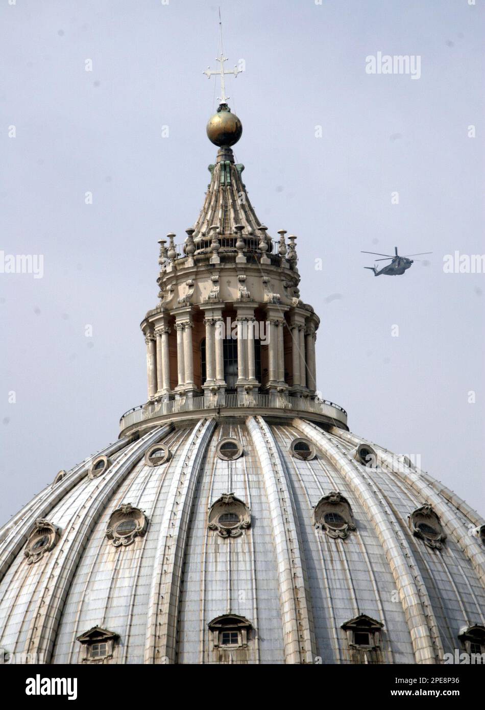A military helicopter flies over the dome of St. Peter's Basilica at ...