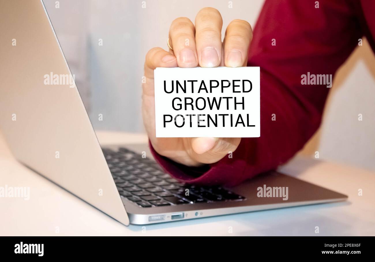 a person holds a card labeled untapped growth potential Stock Photo - Alamy
