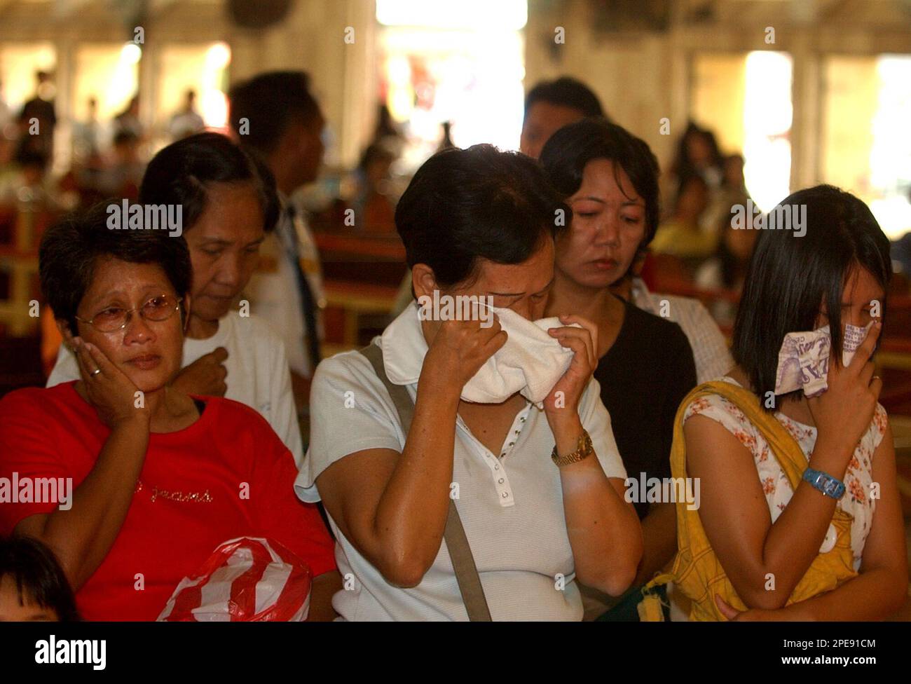 Filipino women grieve at a church in downtown Manila Monday, April 4 ...