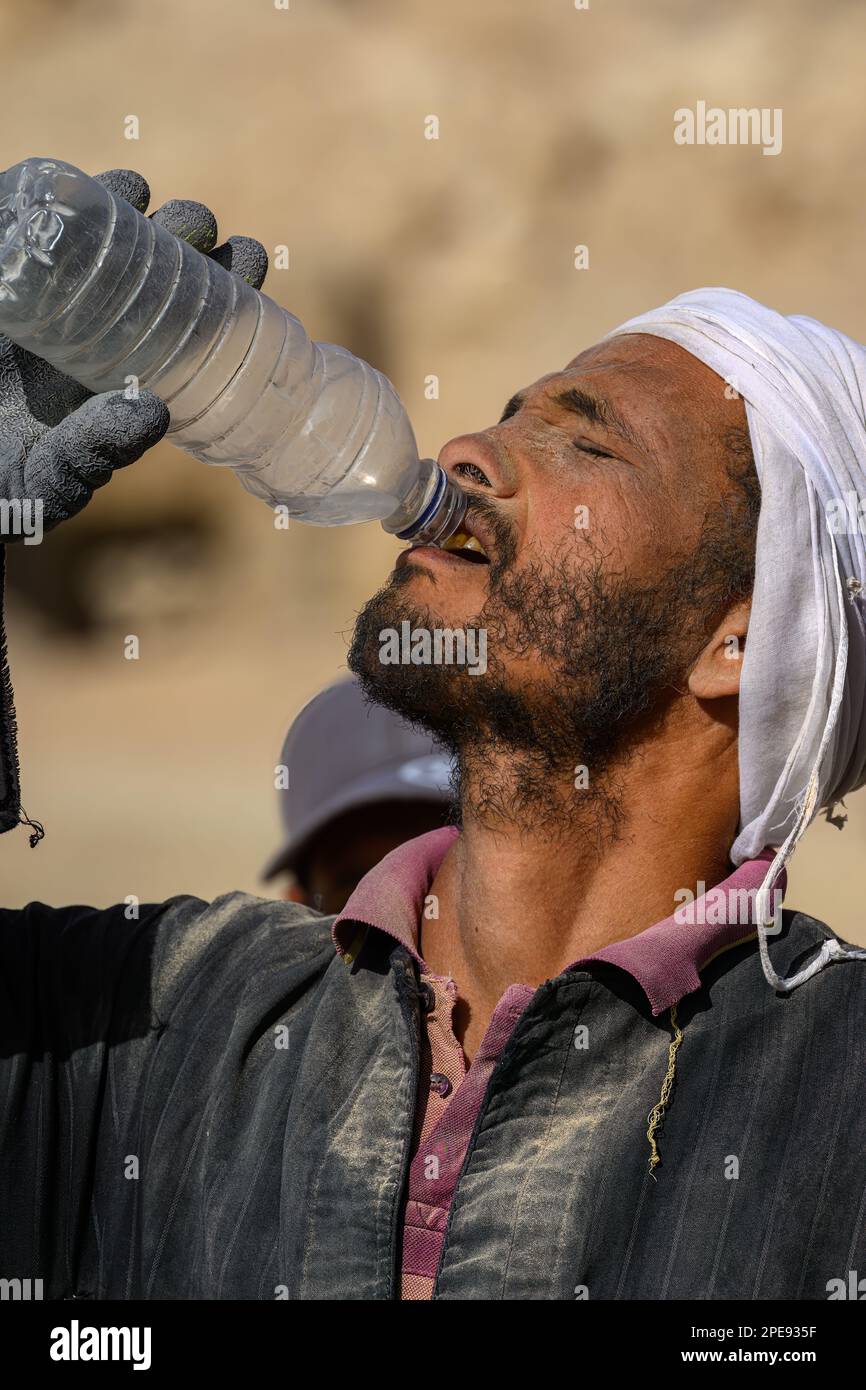 An Egyptian antiquities worker quenches his thirst during a hard days ...