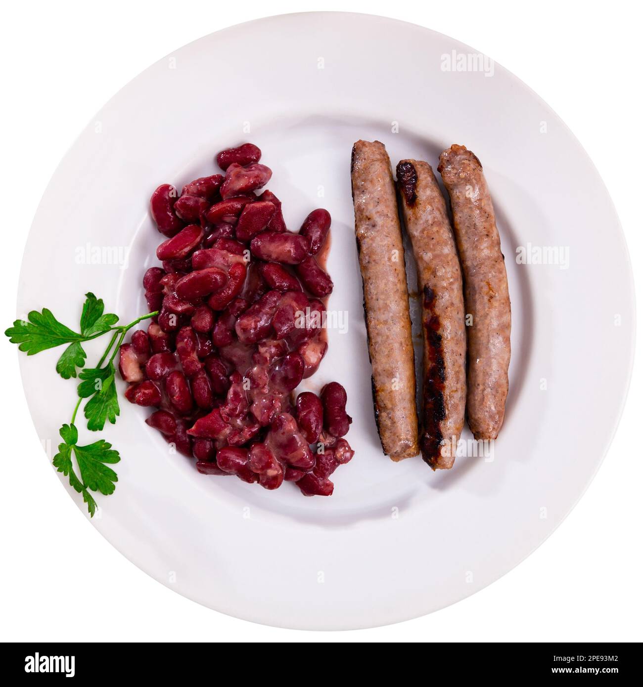 Fried red beans and sausage served on plate and decorated with greenery ...