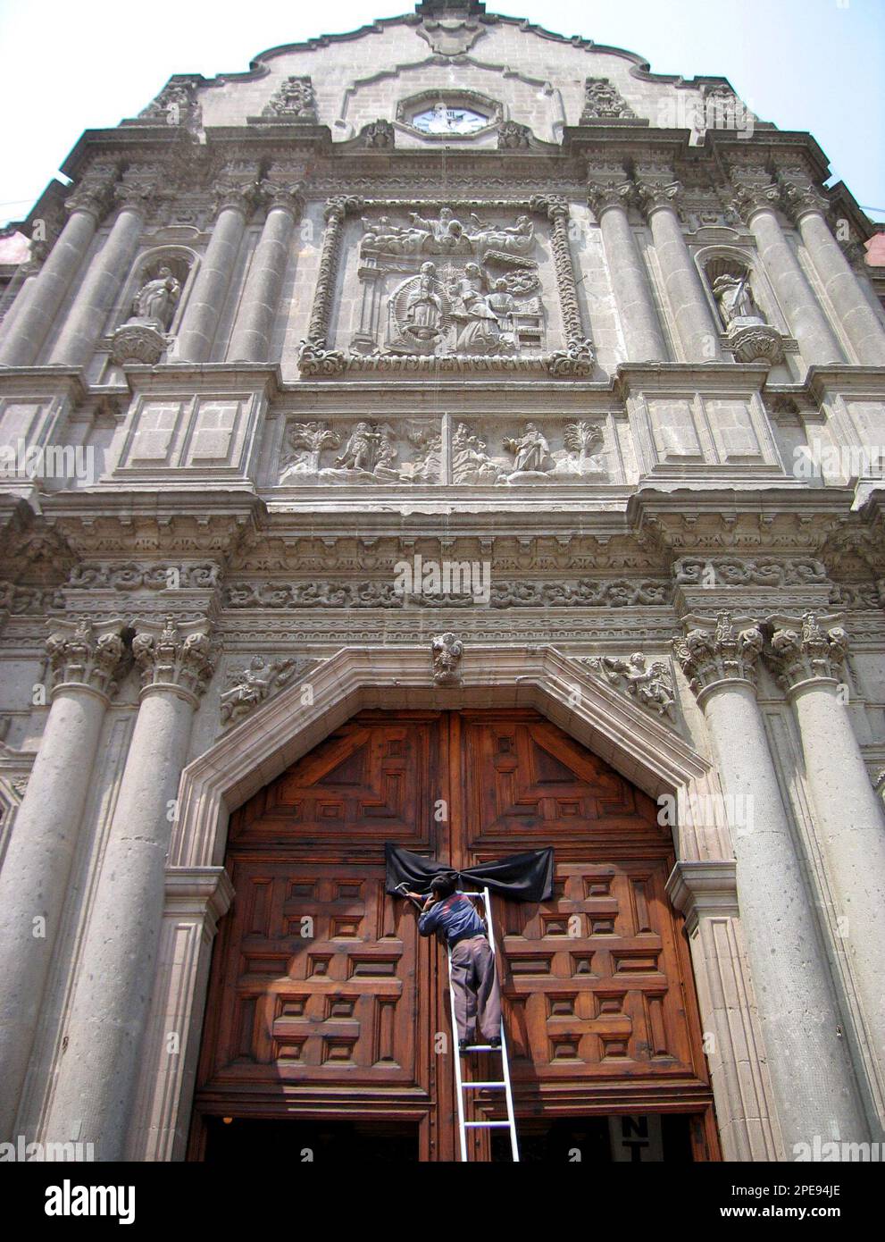 A Basilica employee hangs a black bow on the door of the old Basilica ...