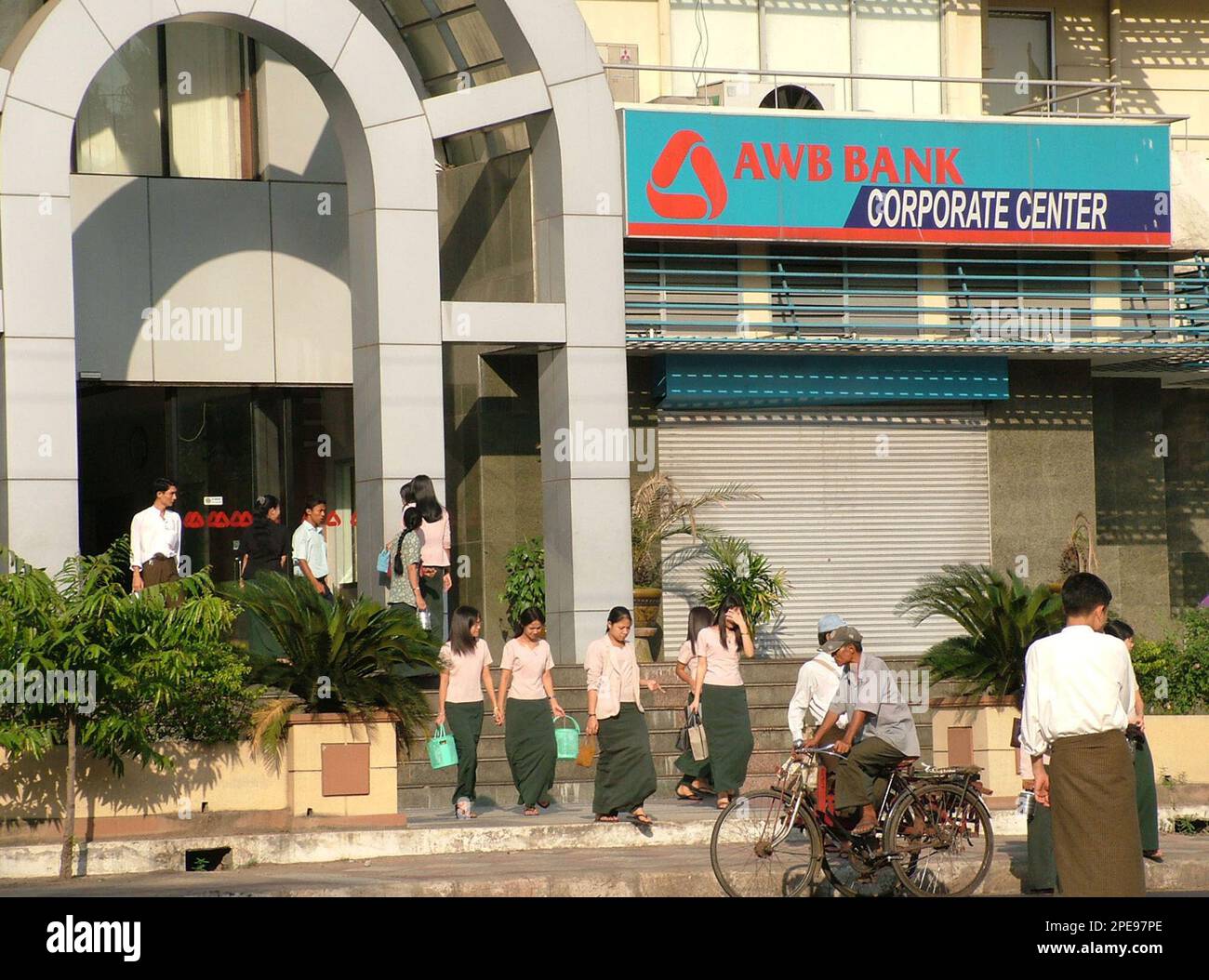 Bank staff in their uniforms leave the head office of the Asia Wealth ...