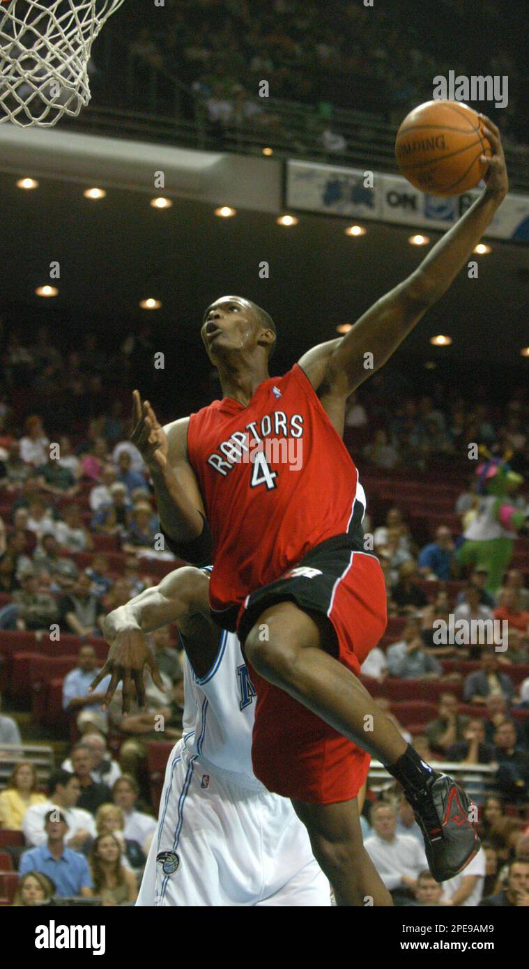 Toronto Raptors forward Chris Bosh, right, puts up a shot past Orlando ...