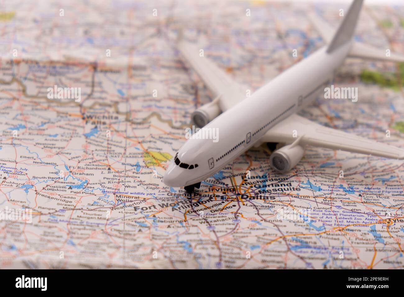 Close up detail of a miniature passenger airplane on a colorful map ...