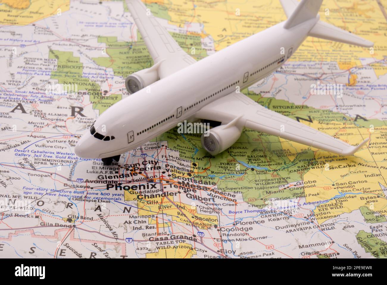 Close up detail of a miniature passenger airplane on a colorful map ...