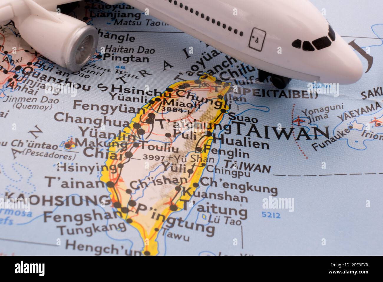 Close up detail of a miniature passenger airplane on a colorful map ...