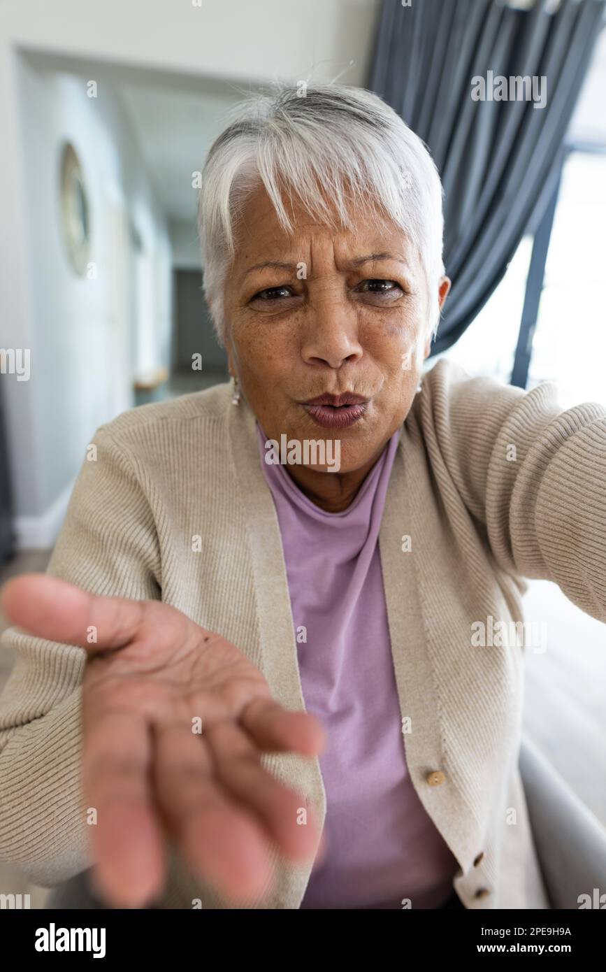 Close-up portrait of biracial senior woman gesturing while talking over ...