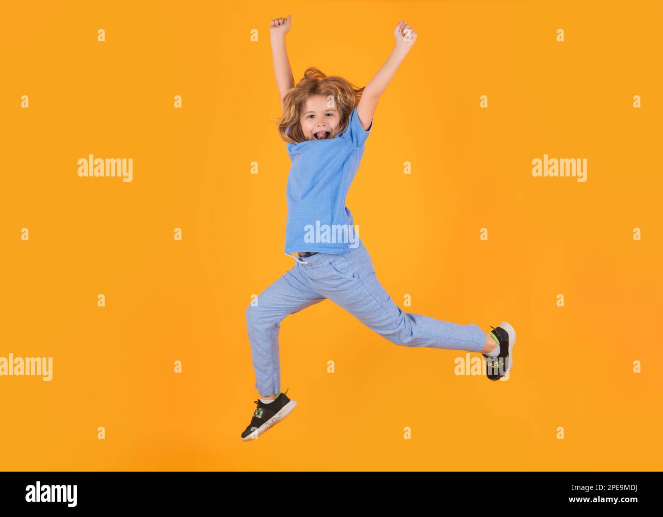 Full length of excited kid jumping. Energetic kid boy jumping and ...