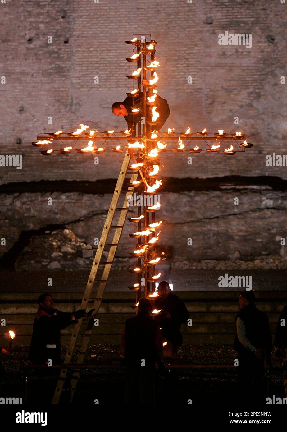 Workers light up a giant cross before the Via Crucis (Way of the Cross ...