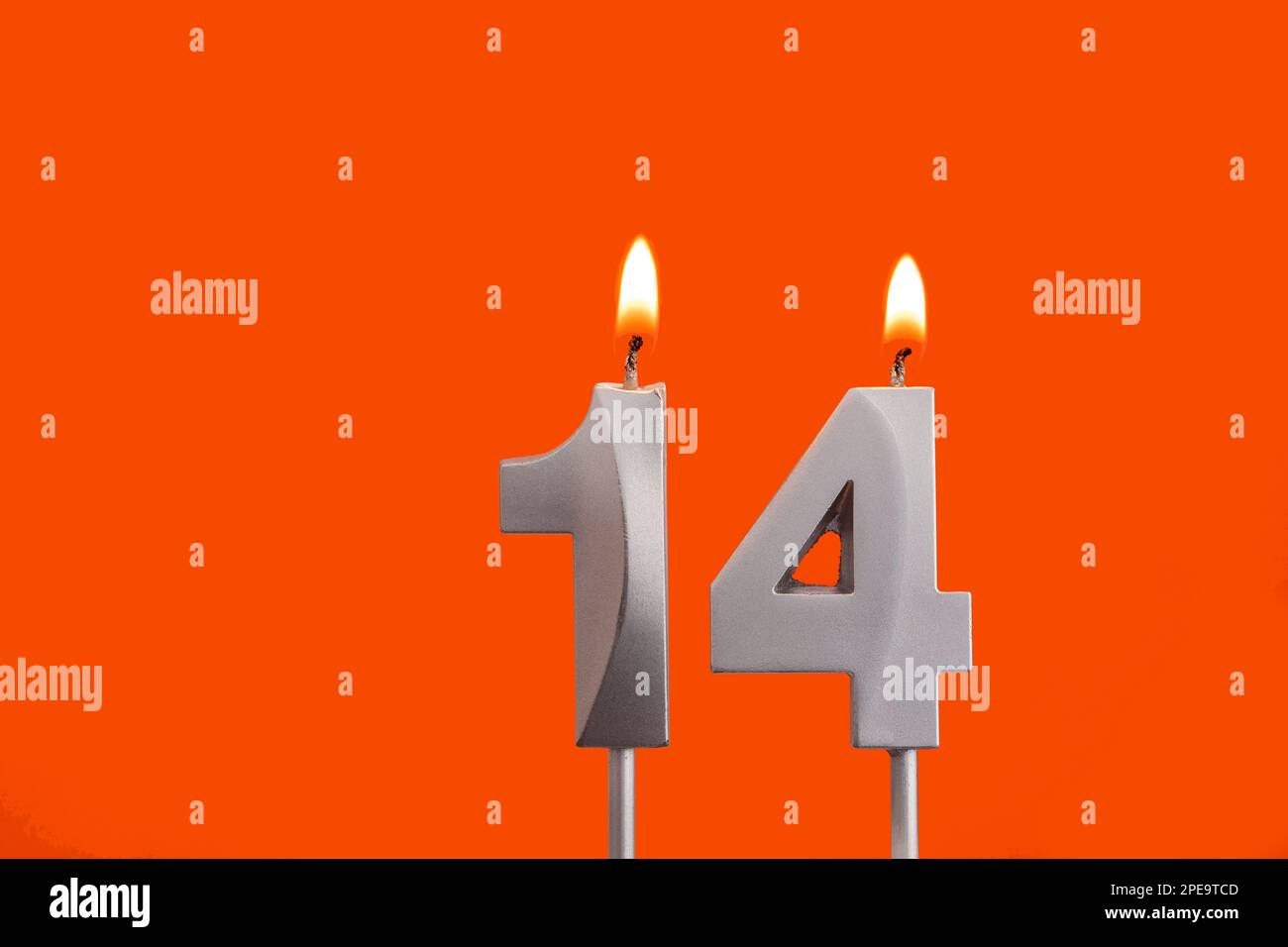 Candle number 14 - Birthday in orange background Stock Photo - Alamy
