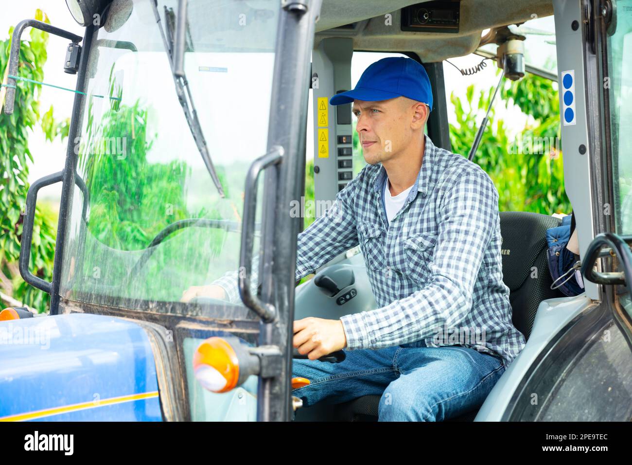 Portrait of male worker working on tractor Stock Photo - Alamy