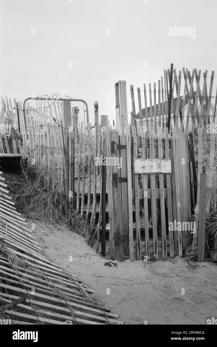 A storm fence and wooden gate with a sign reading Privat Keep Out below ...