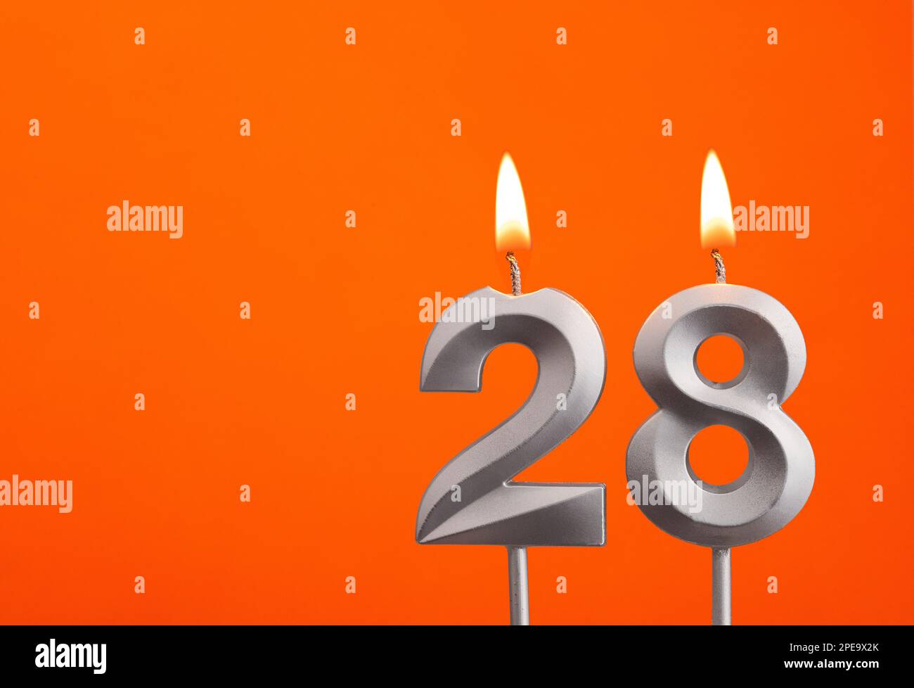 Candle number 28 - Birthday in orange background Stock Photo - Alamy