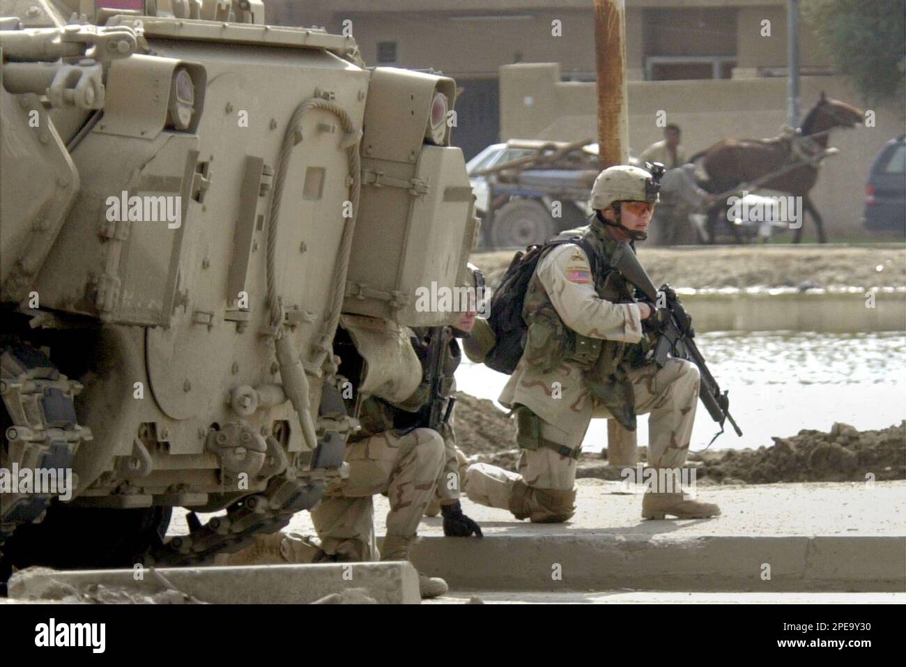 U.S. Army soldiers take cover at the scene after a car was destroyed by ...