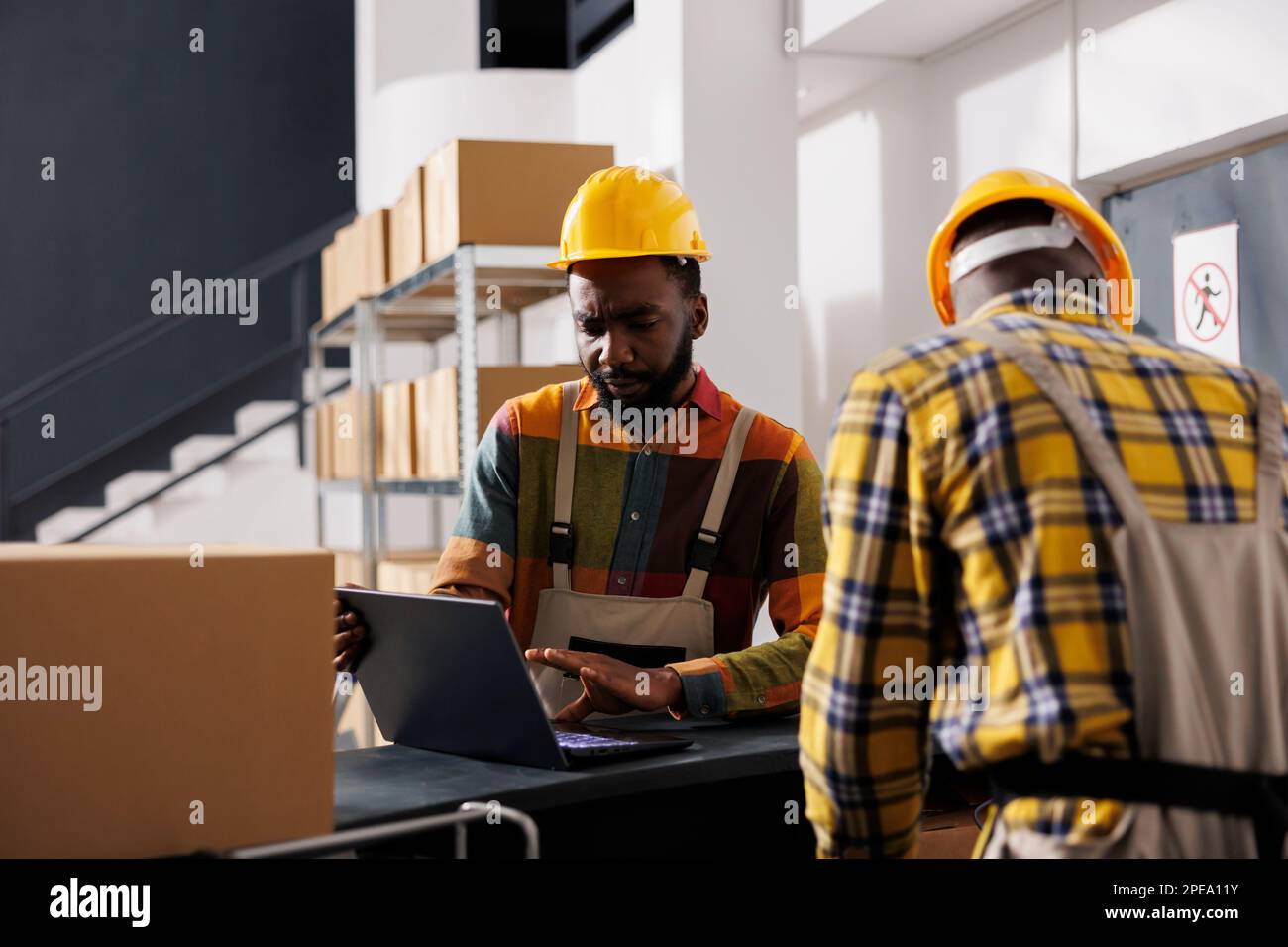 Warehouse manager checking parcel delivery electronic invoice on laptop ...