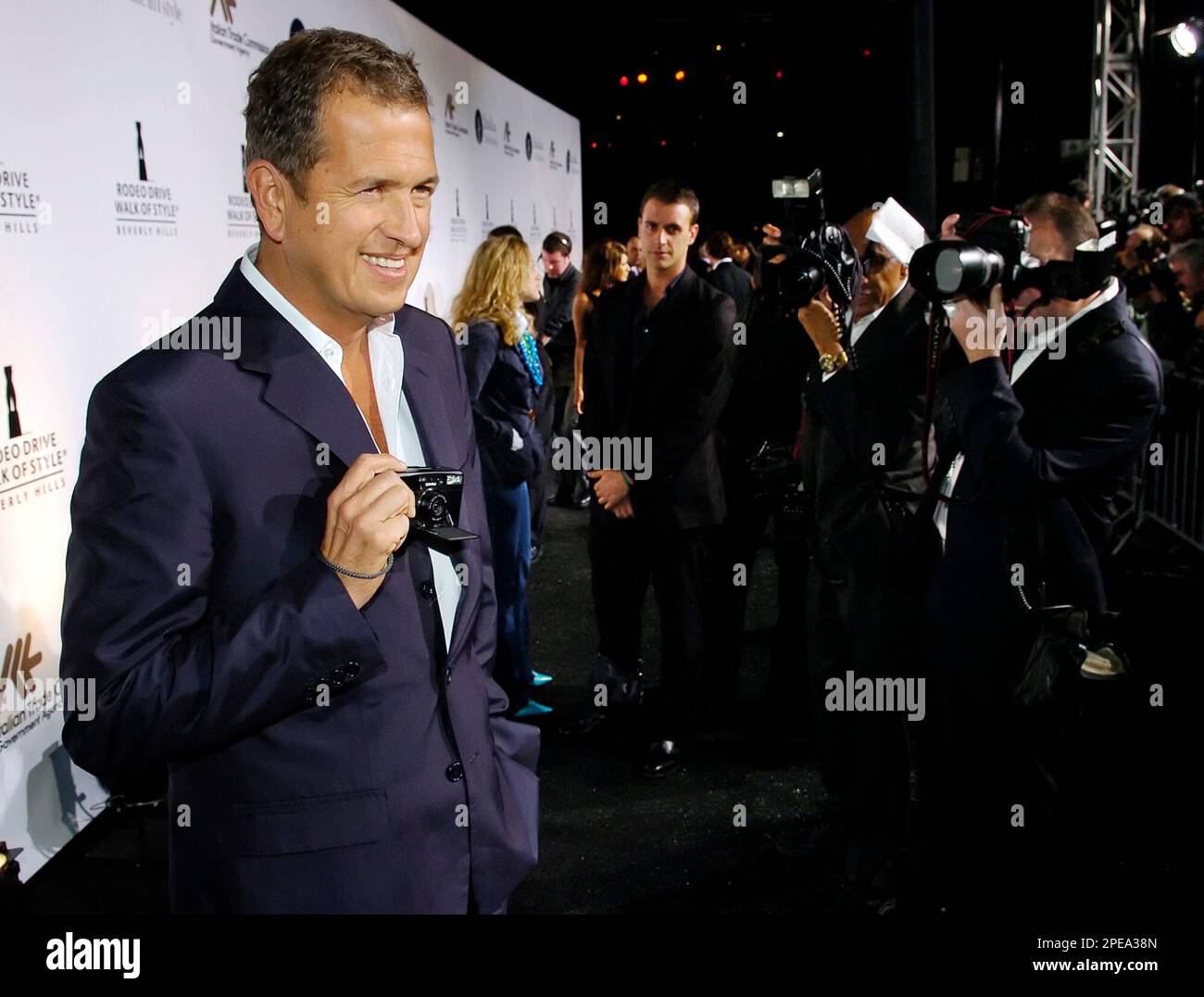 Fashion photographer Mario Testino poses with one of his cameras upon ...