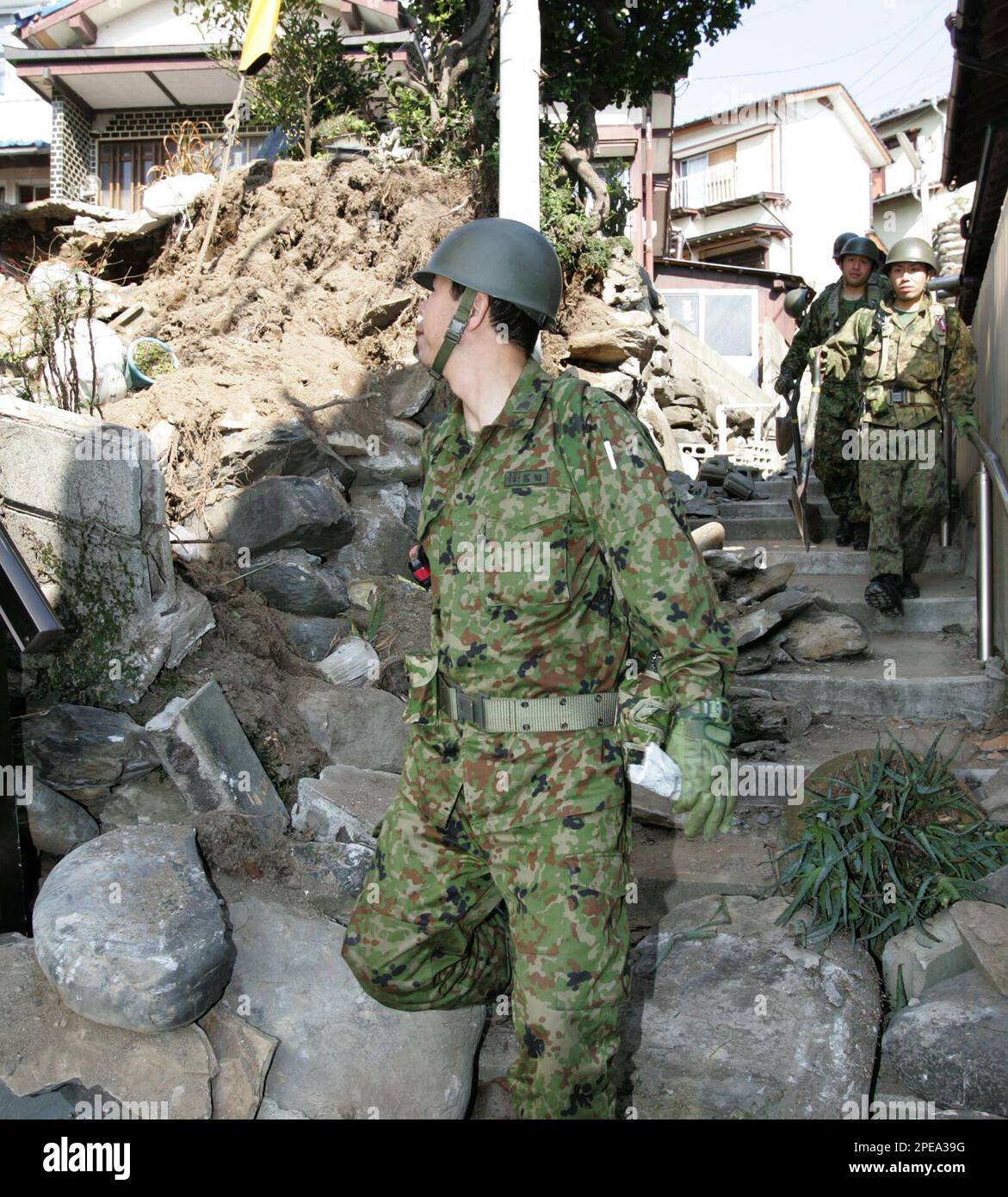 Soldiers of Japan Self-Defense forces walk down damaged slope on ...