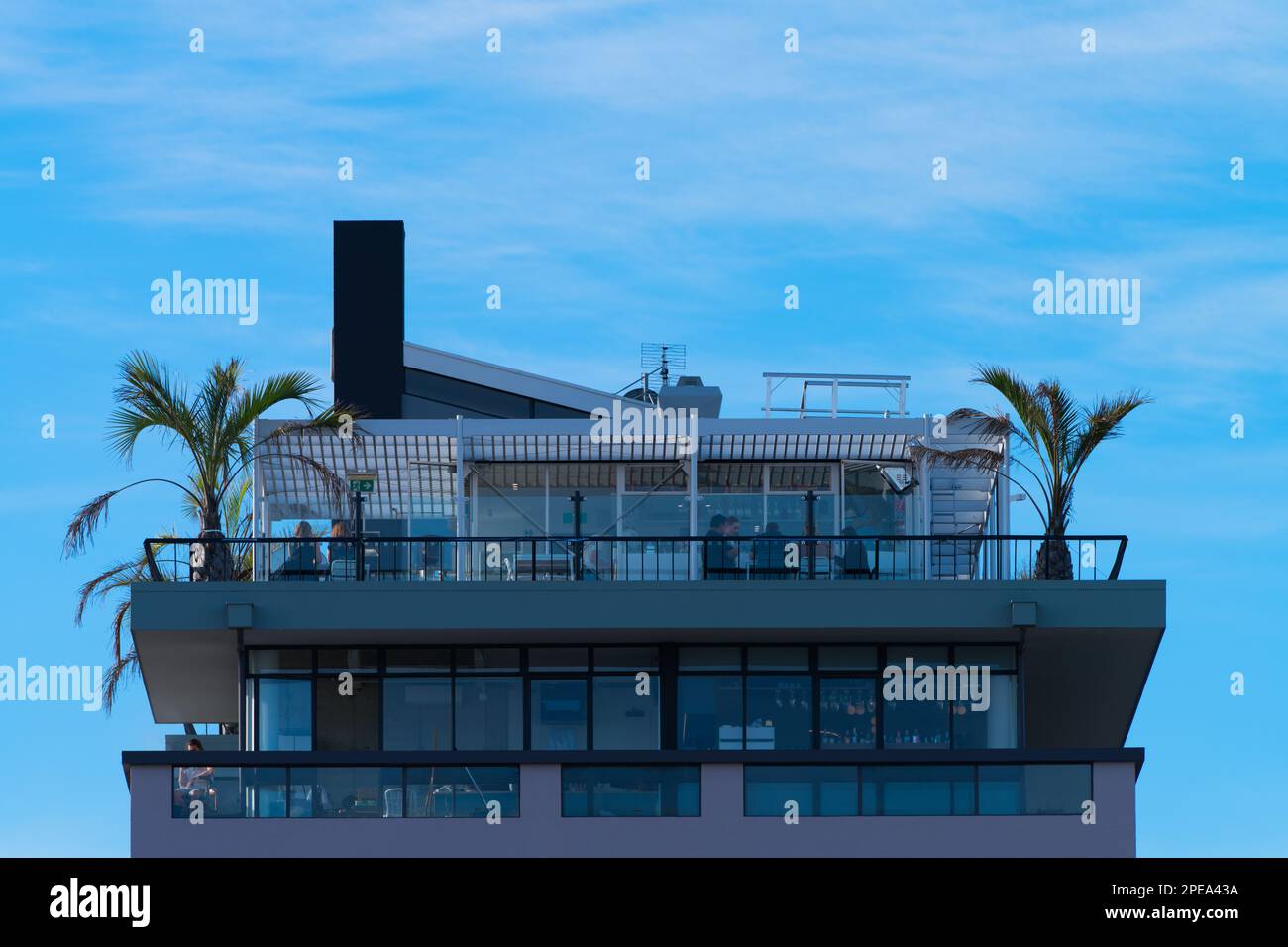 People dining at a rooftop restaurant and bar in the evening light ...