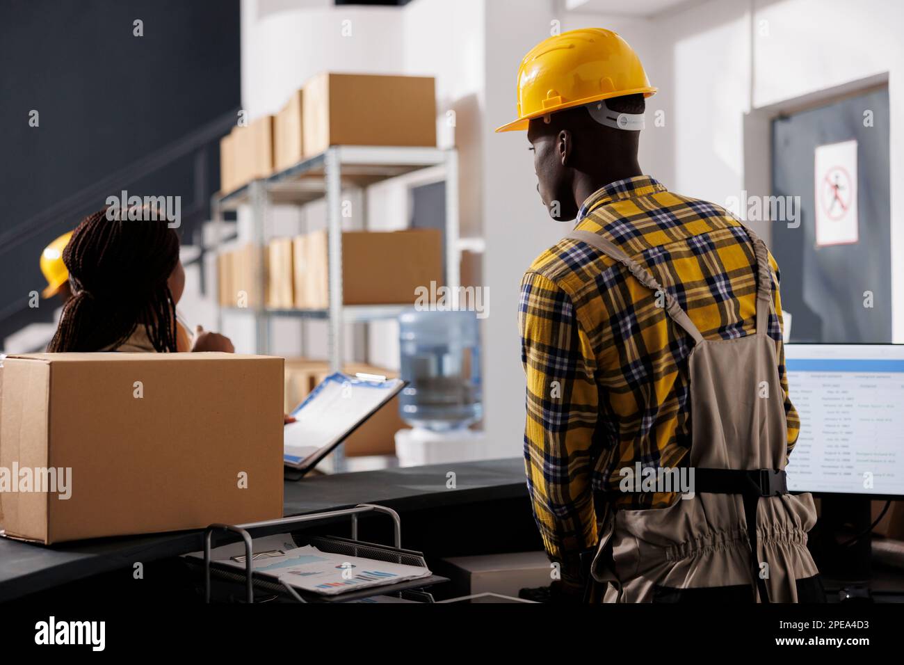 Courier checking orders list and receiving parcel in retail storehouse ...