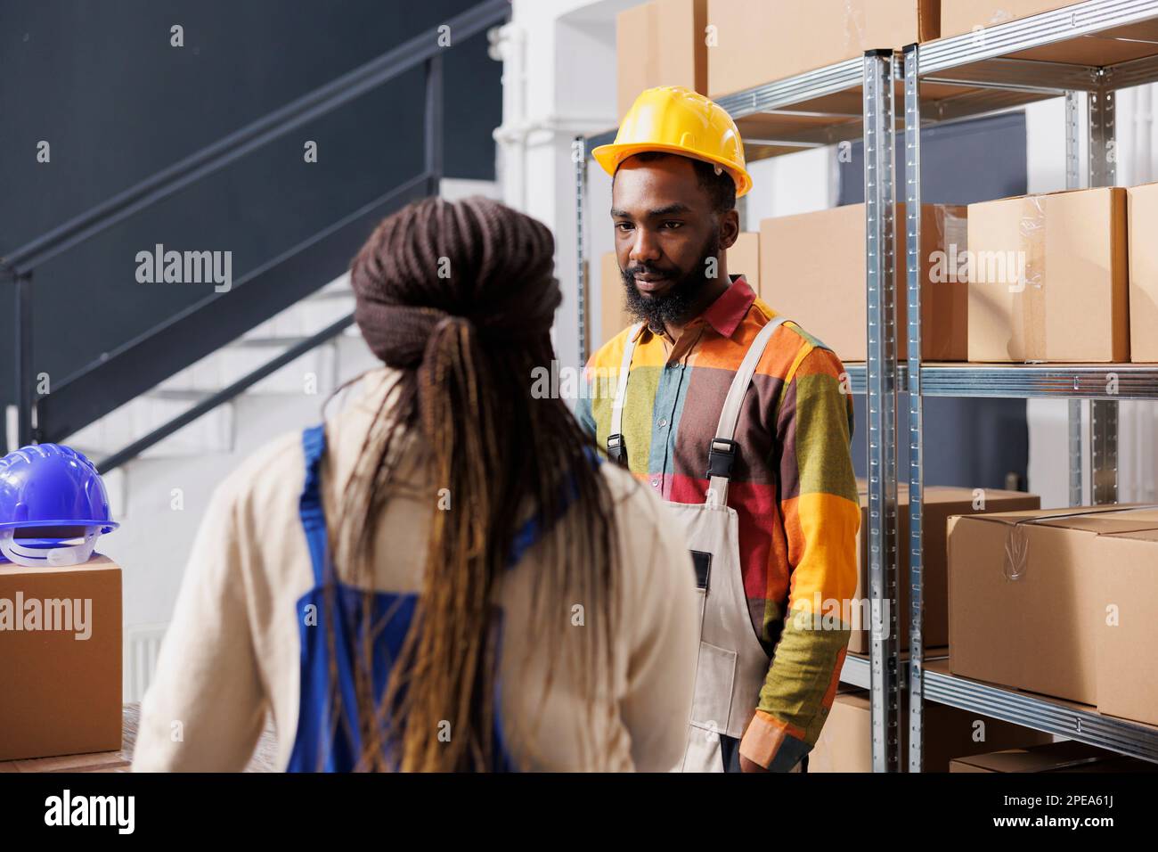 African american postal warehouse trainee listening to manager ...