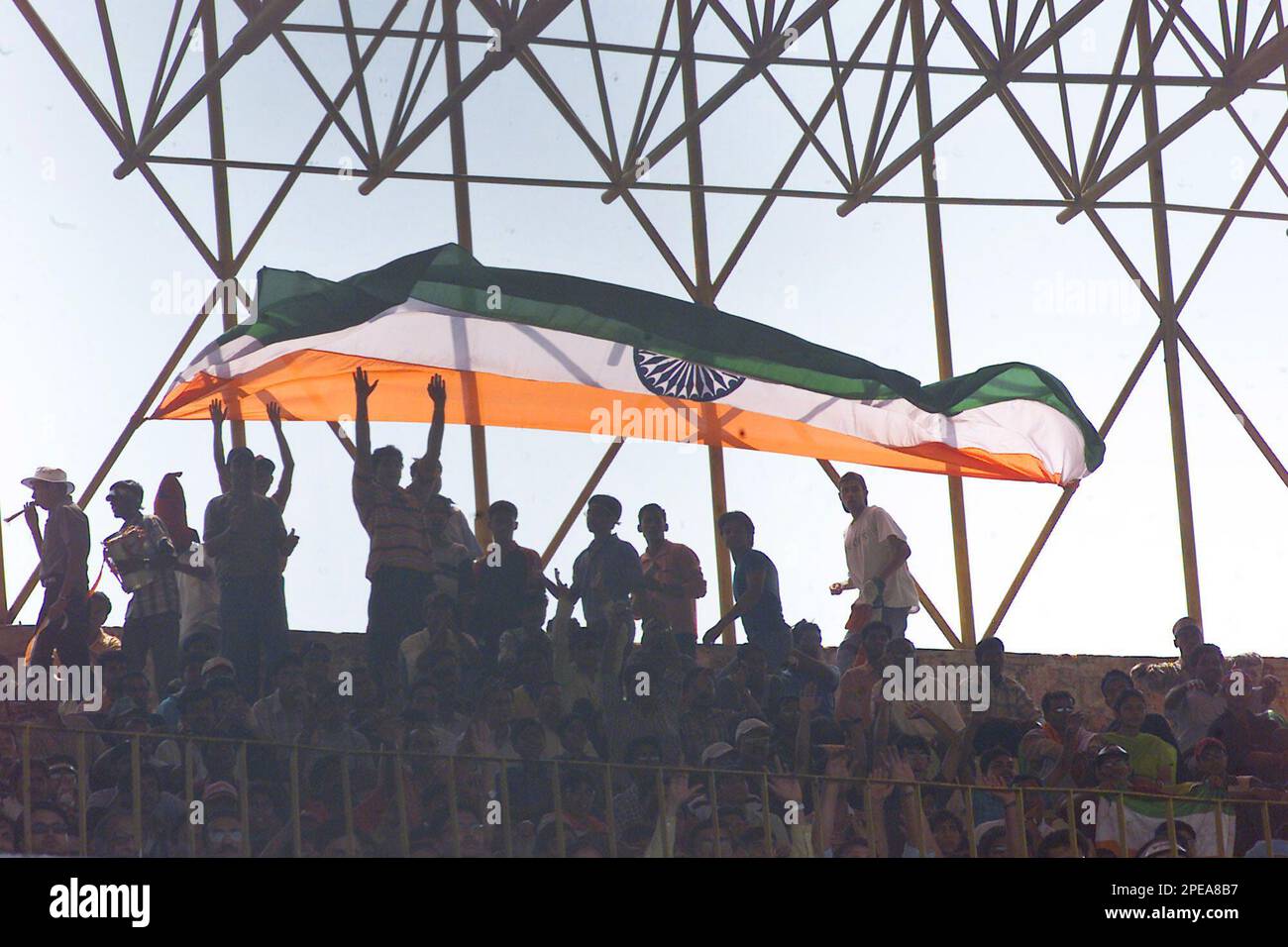 Indian cricket fans wave the national flag while cheering for their ...