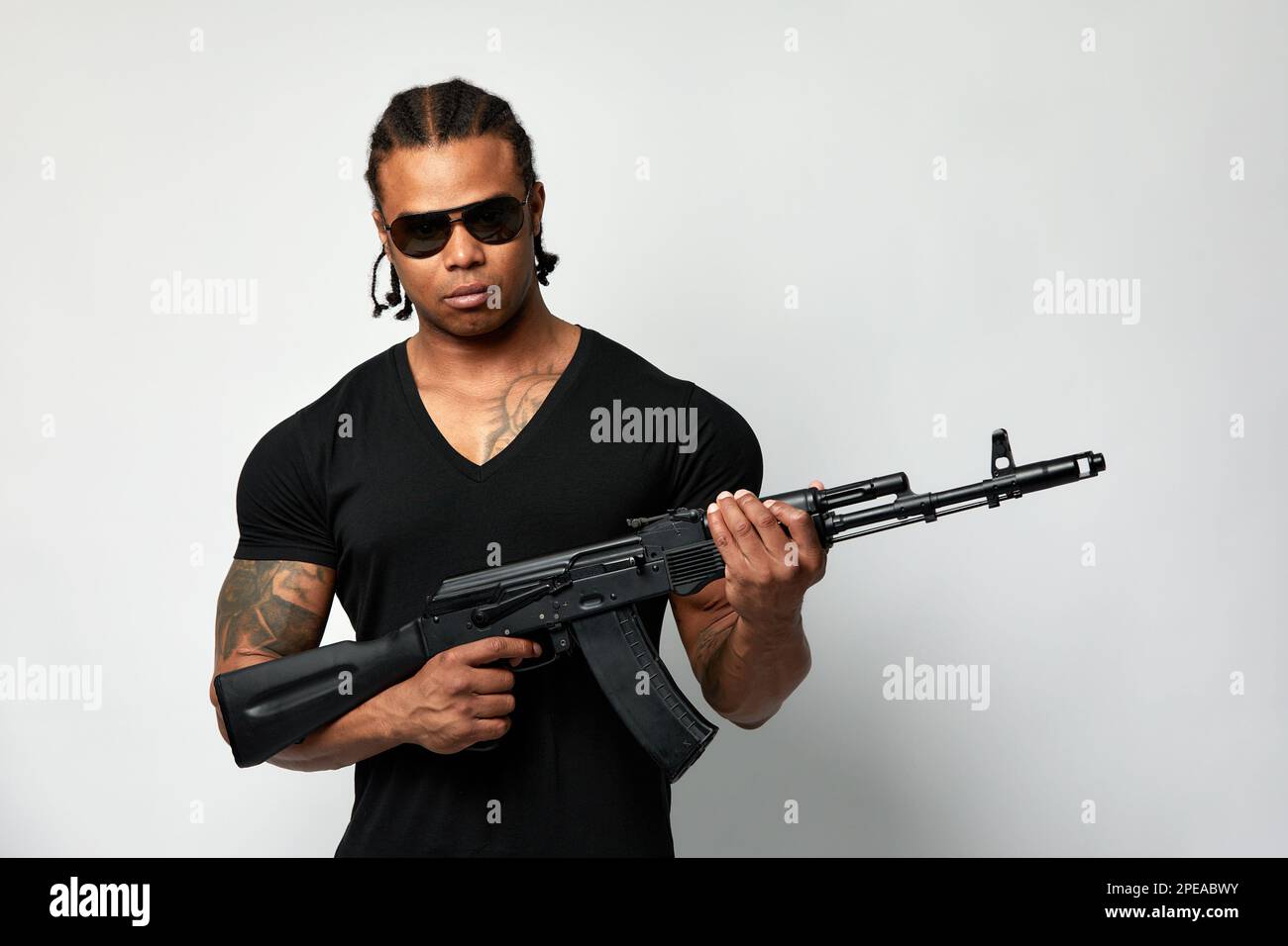 African American in a black jacket with a machine gun in his hands and ...