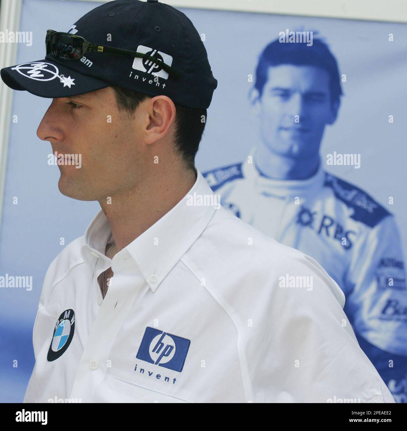 Australian F1 driver Mark Webber of BMW Williams walks past a poster of ...