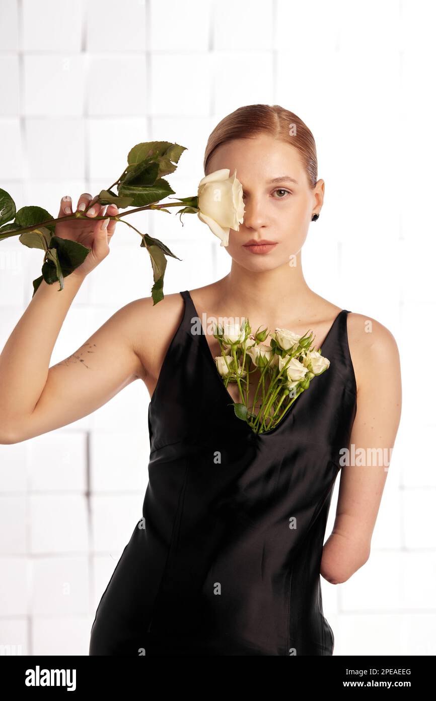 Beautiful young with special needs woman with flowers in her hand ...