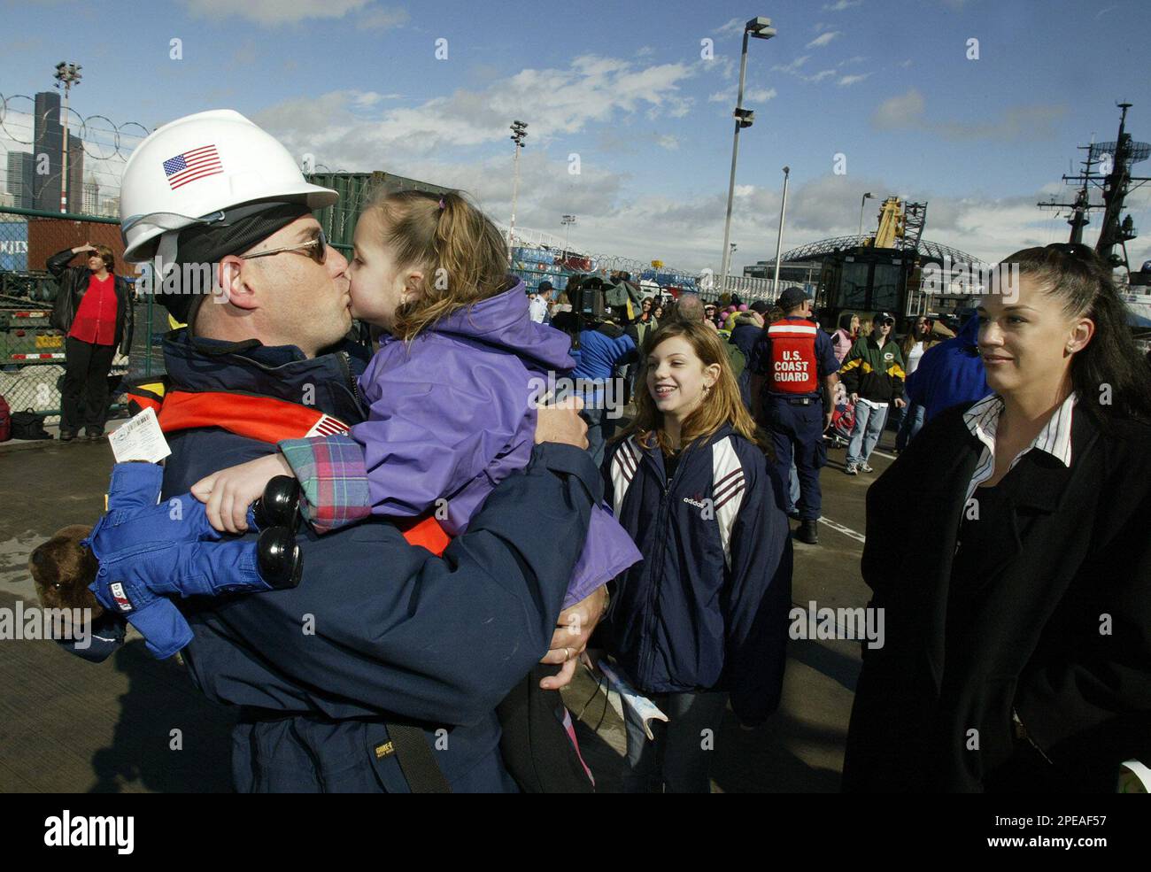 U.S. Coast Guard Chief Boatswain's Mate Cory Evers, left, of Bellingham, Wash., kisses his ...