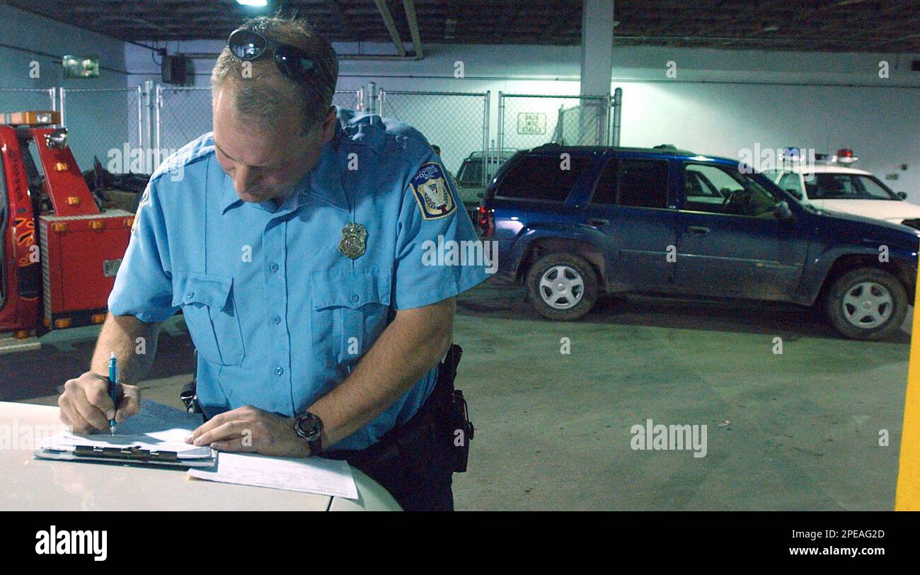 Racine police officer Brian Neubauer fills out a report after Angela ...