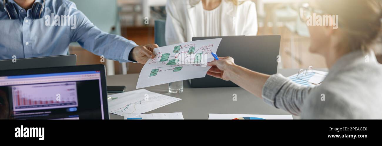 Group of busy coworkers working together analyzing the charts in modern ...