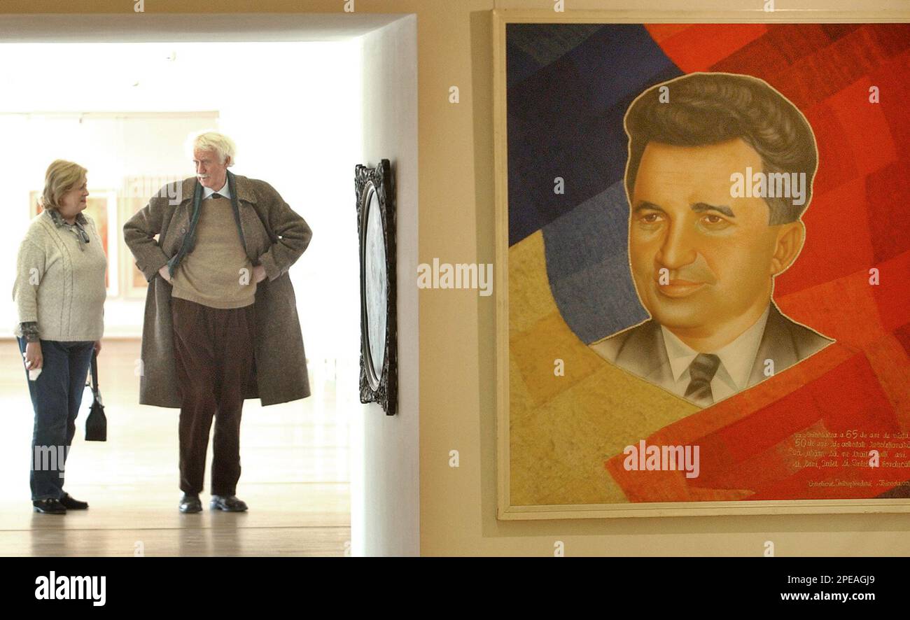 Visitors pause next to a painting depicting former Romanian communist ...