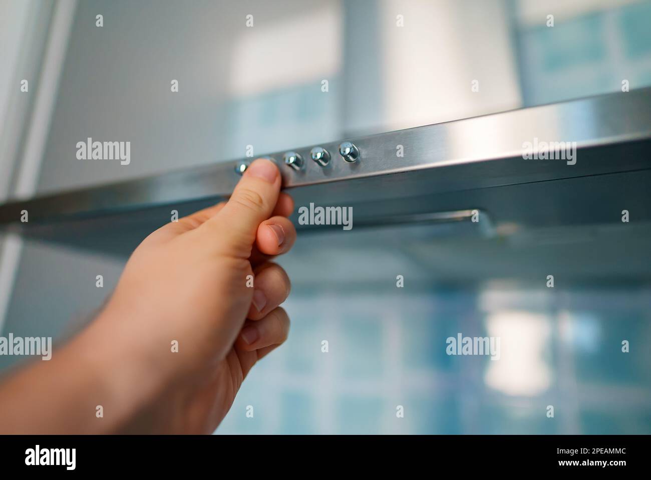 Man hand select mode on cooking exhaust hood Stock Photo - Alamy