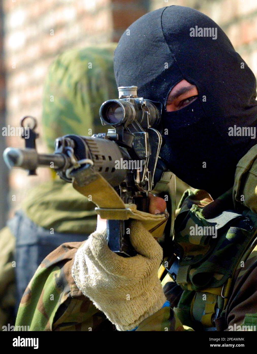 A Russian sniper uses his rifle's sight to observe an area near the ...