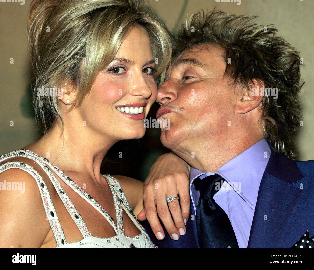 Rock star Rod Stewart kisses his girlfriend model Penny Lancaster ...