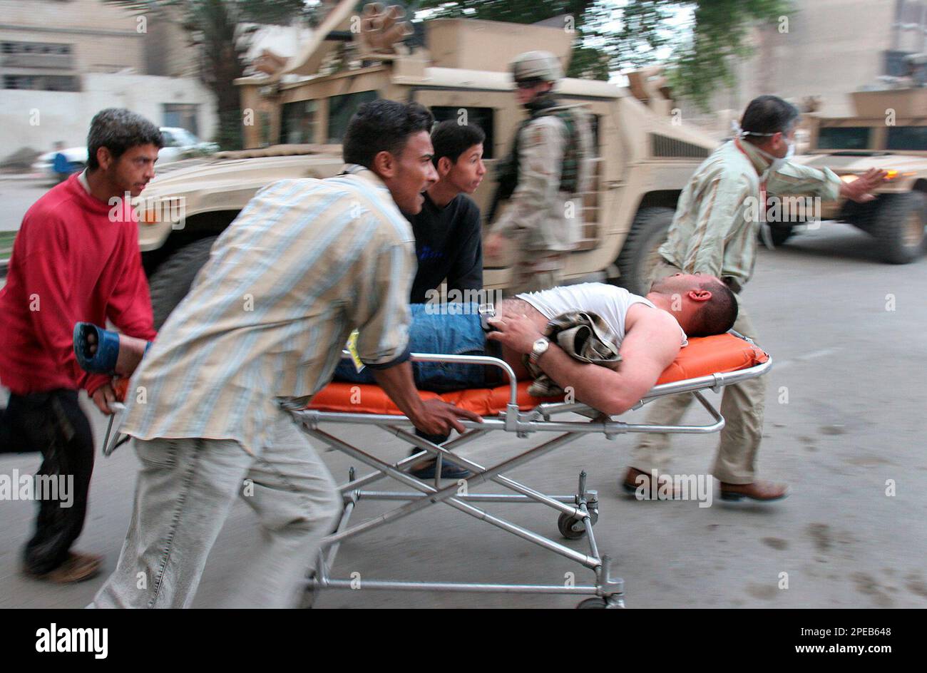 An injured man is rushed from the scene after a garbage truck exploded ...
