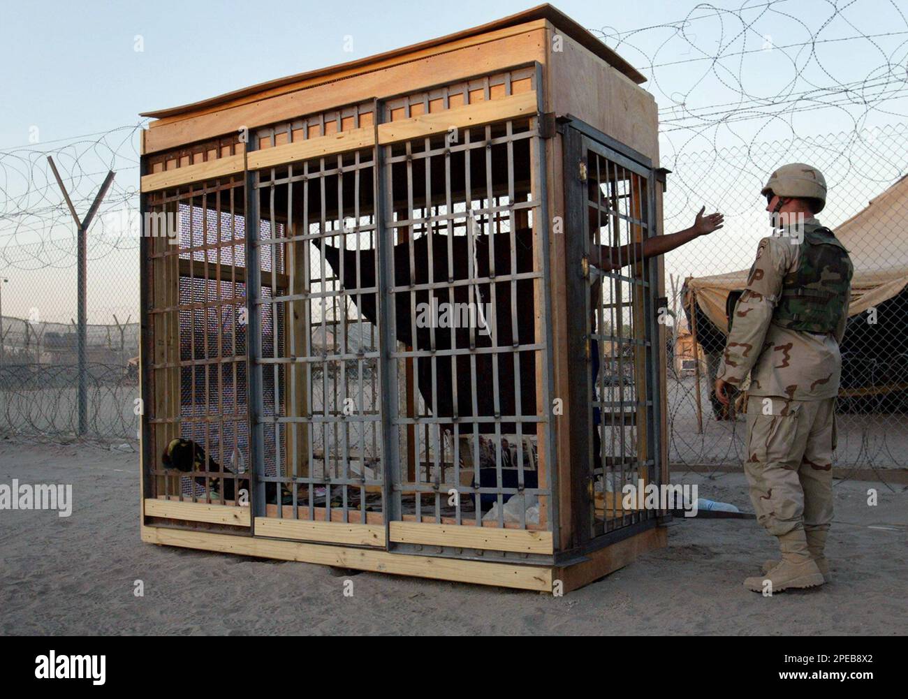 **FILE** A detainee in an outdoor solitary confinement cell talks with ...