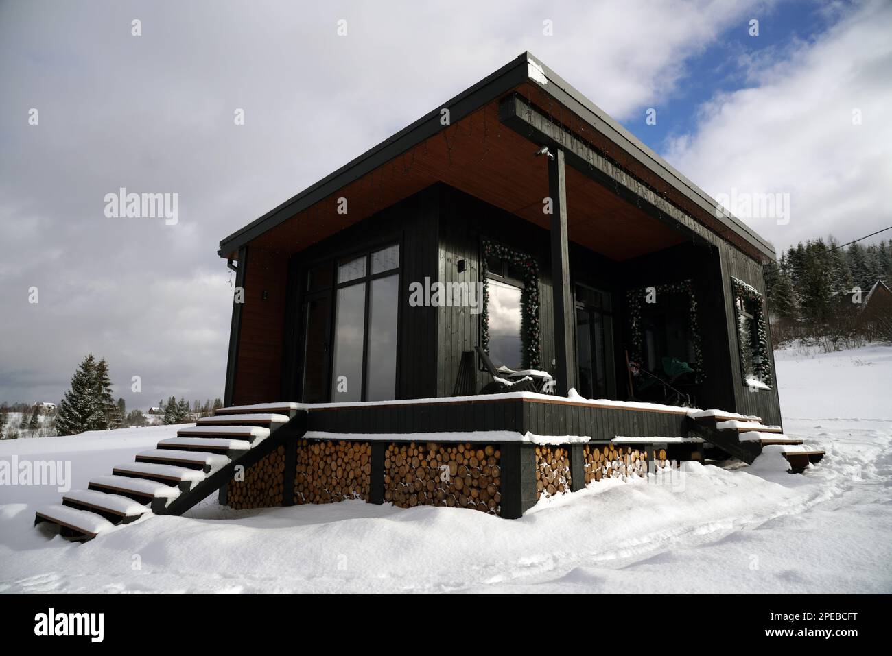 Modern black tiny cabin in snowy weather Stock Photo - Alamy