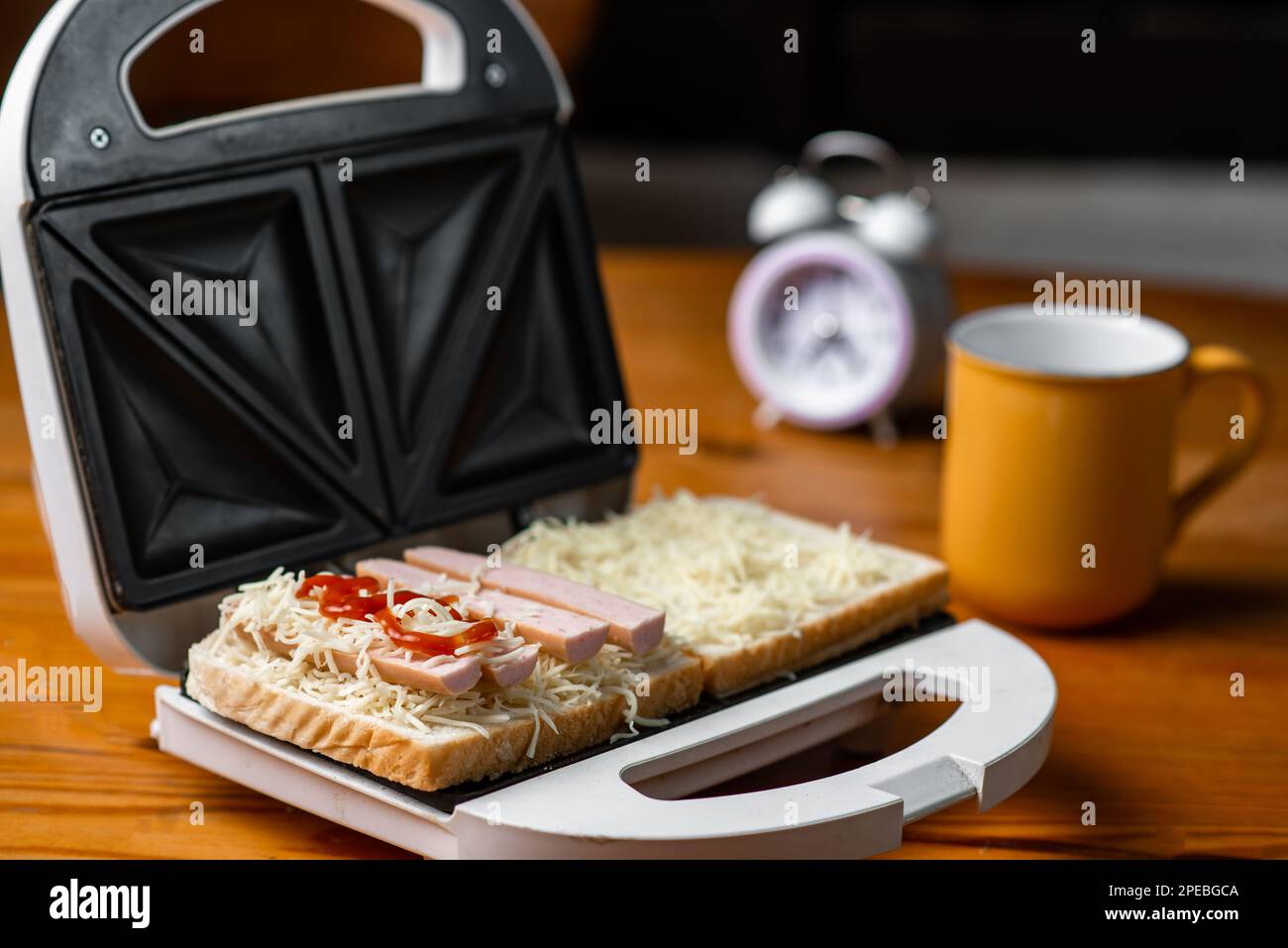 open sandwich maker with cheese toast and sausages. Sandwiching Stock ...