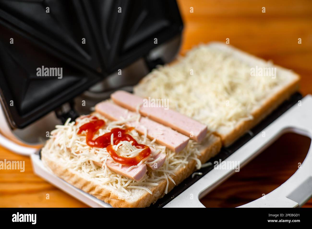 open sandwich maker with cheese toast and sausages. Sandwiching Stock ...