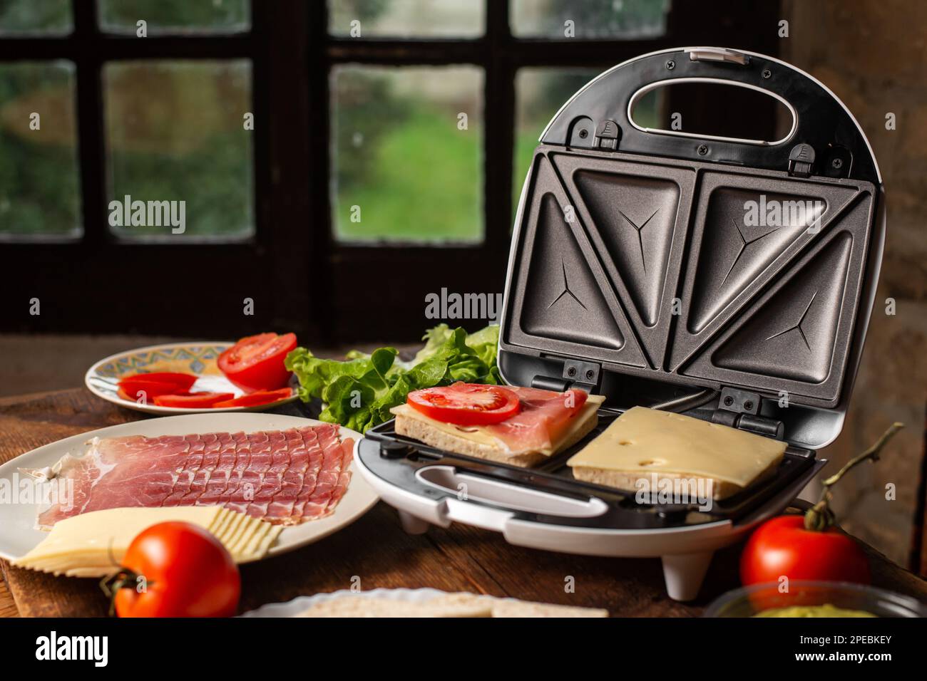Sandwich maker. Cooking sandwiches with different fillings Stock Photo ...