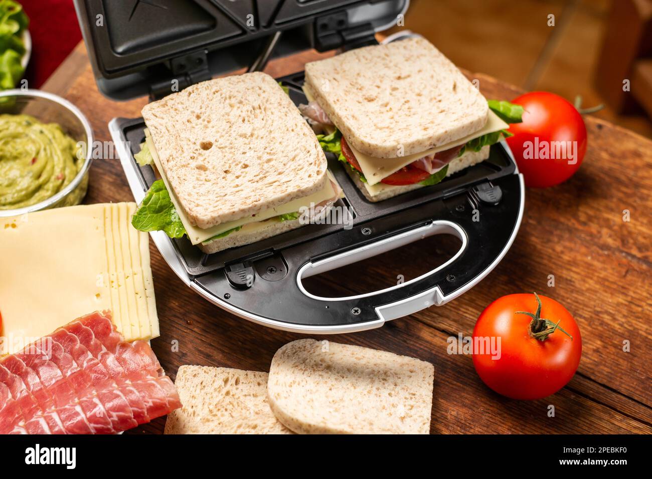 Sandwich maker and various ingredients on a wooden background. Cooking ...