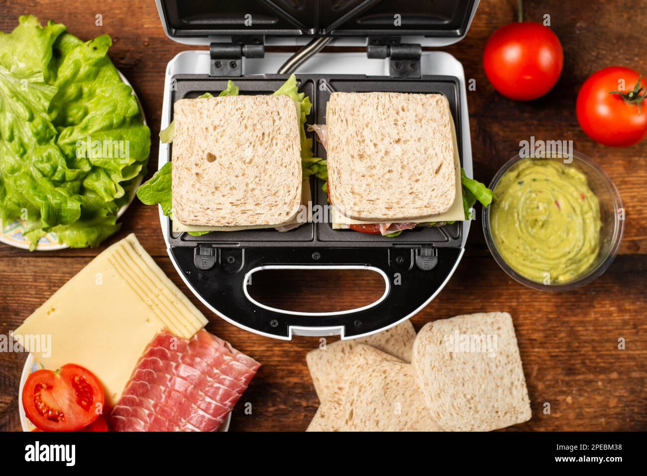 Sandwich maker and various ingredients on a wooden background. Cooking ...